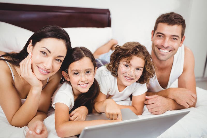 Portrait of Happy Children with Parents Using Laptop on Bed Stock Image ...