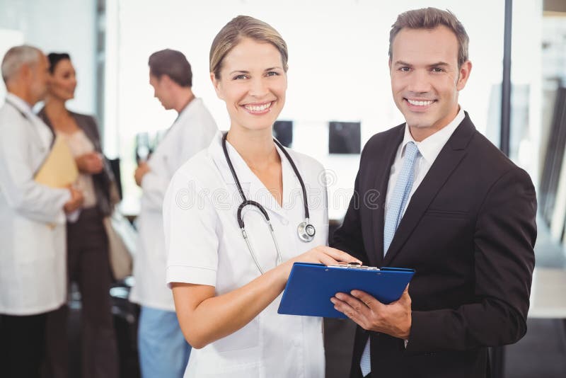Portrait of Happy Doctors with Clipboard Stock Photo - Image of coat ...