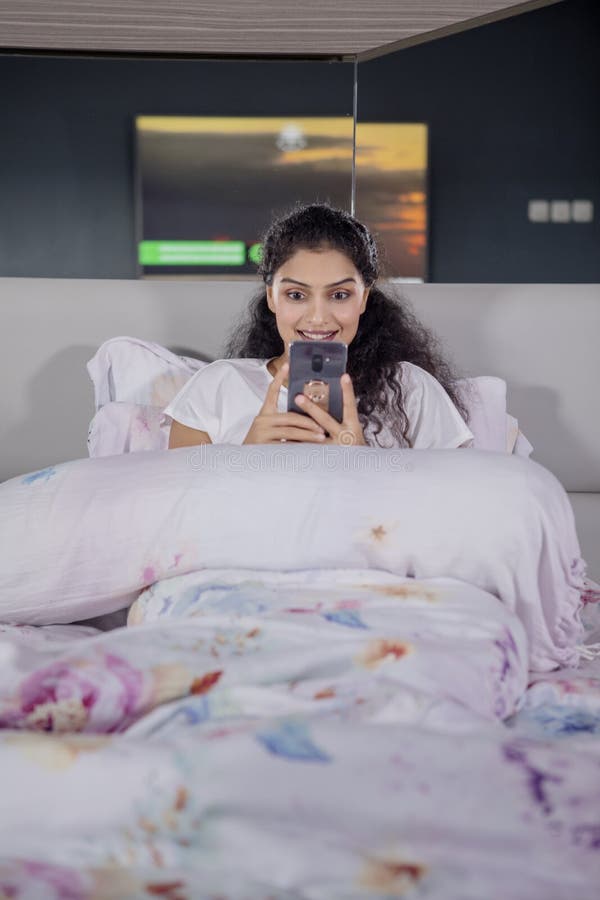 Happy Indian Woman Using Mobile Phone on Bed Stock Photo - Image of ... Happy Indian Woman Using Mobile Phone on Bed Stock Photo - Image of ...