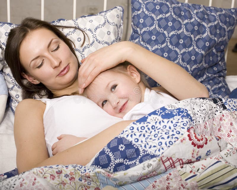 Portrait Of Happy Mother And Daughter In Bed Hugging And Smiling Stock