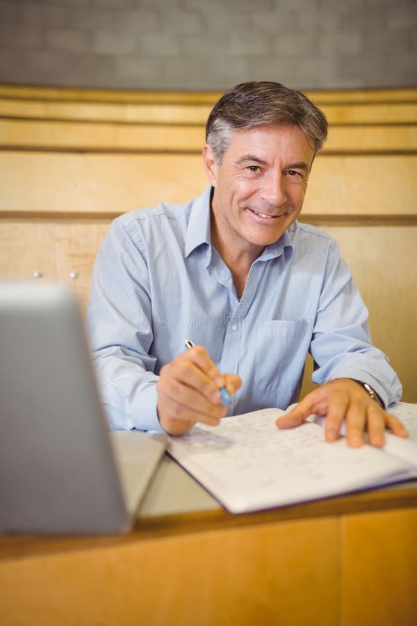 Portrait of Happy Professor Writing in Book at Desk Stock Photo - Image ...