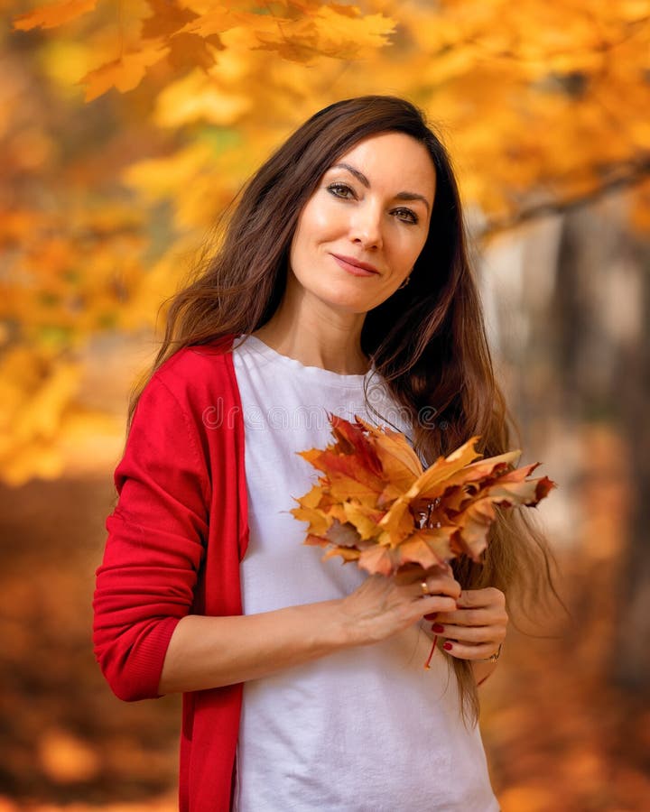 Portrait Of Happy Woman With Long Hair Playing With Yellow Autumn