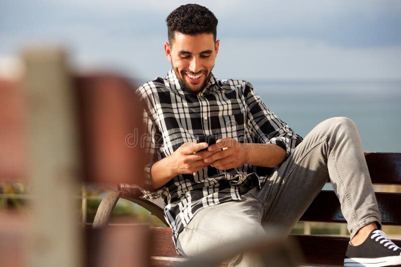 Happy Young Arabic Man Sending Text Message on Mobile Phone Stock Photo ...