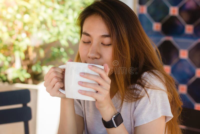 Portrait of Happy Young Asian Business Woman with Mug in Hands Drinking ... Portrait of Happy Young Asian Business Woman with Mug in Hands Drinking ...