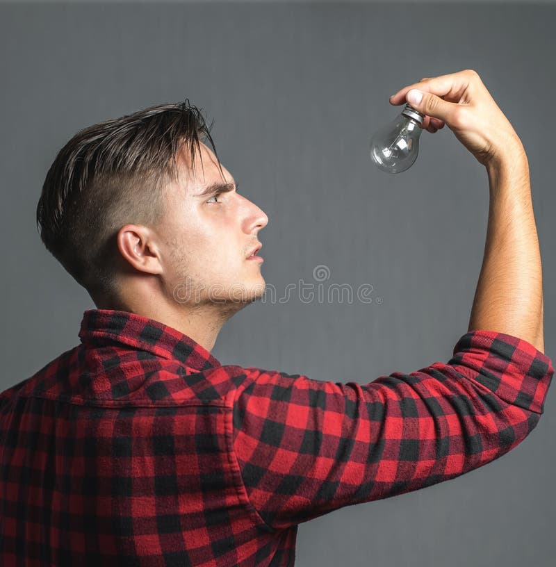 Portrait of a Happy Young Man Holding Light Bulb Stock Image - Image of ...