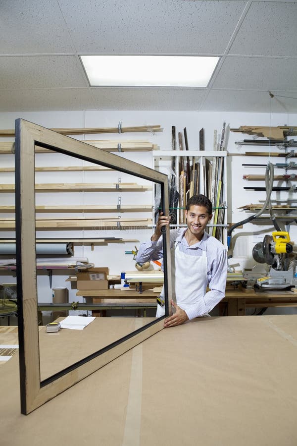 Portrait Of A Happy Young Man Working On Big Picture Frame In Workshop ...