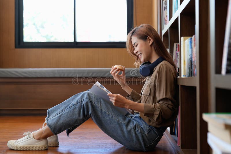 Portrait of a Happy Young Student Reading a Book in a Library Stock ...