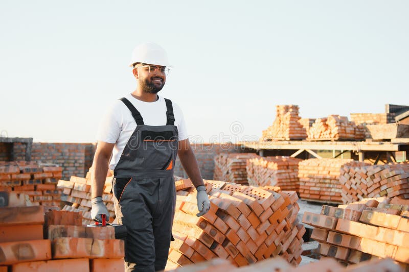 Portrait of an Indian Construction Worker in Overalls and a Hard Hat at ...