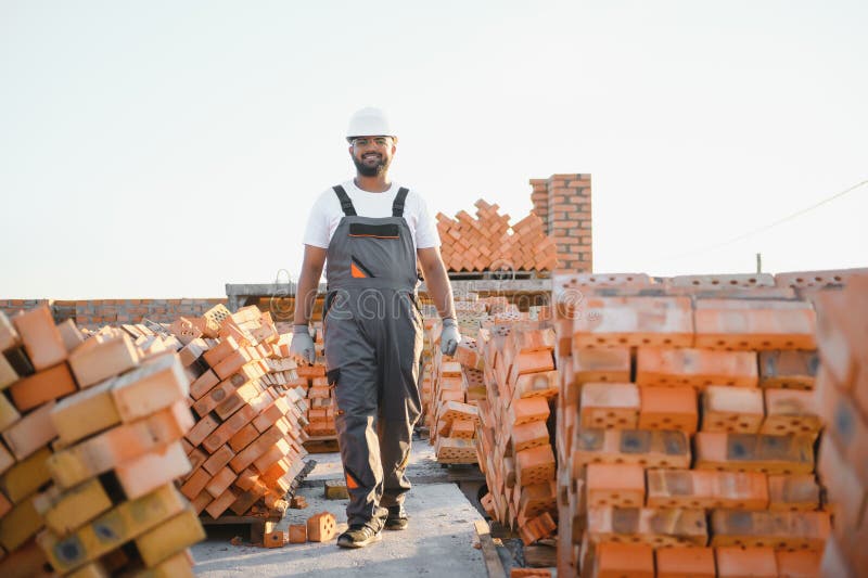 Portrait of an Indian Construction Worker in Overalls and a Hard Hat at ...