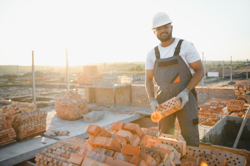 Portrait of an Indian Construction Worker in Overalls and a Hard Hat at ...