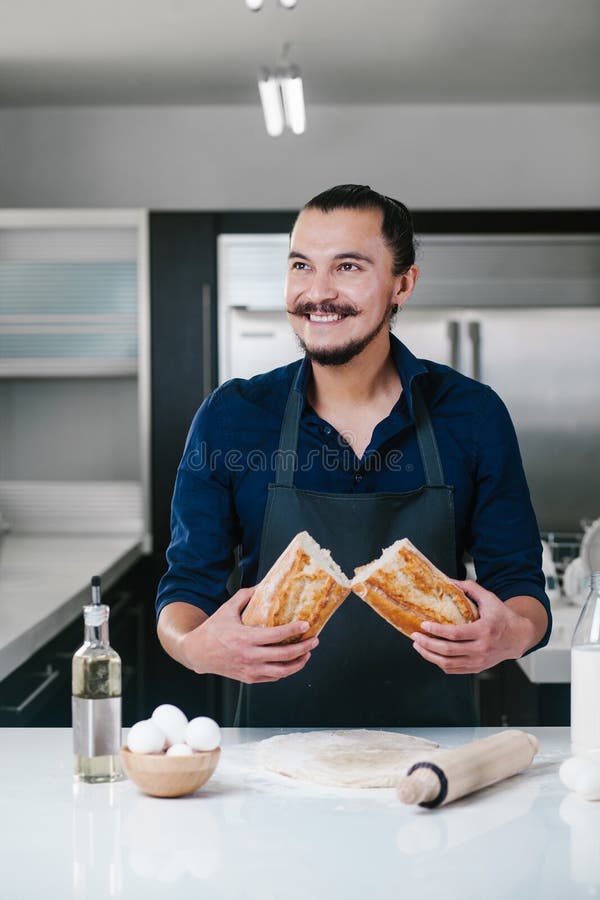 Portrait of Latin Man Baking and Holding Bread at Kitchen in Mexico ...