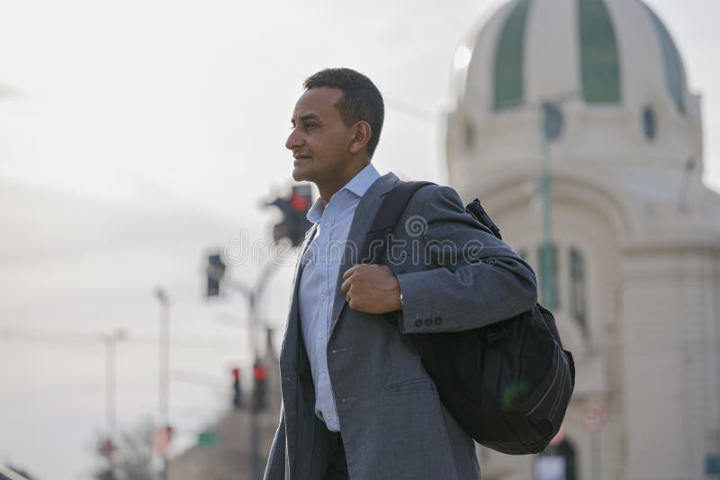 Portrait of Latino Man in a Suit and Backpack Crossing the Pedestrian ...