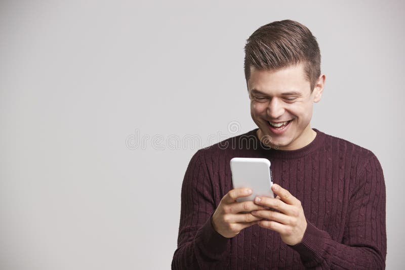 Portrait of a Laughing Young White Man Using a Smartphone Stock Photo ...
