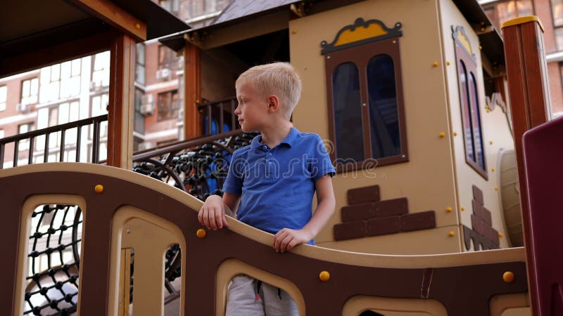 Portrait of a Little Boy on a Modern Playground, he Stands on the ...