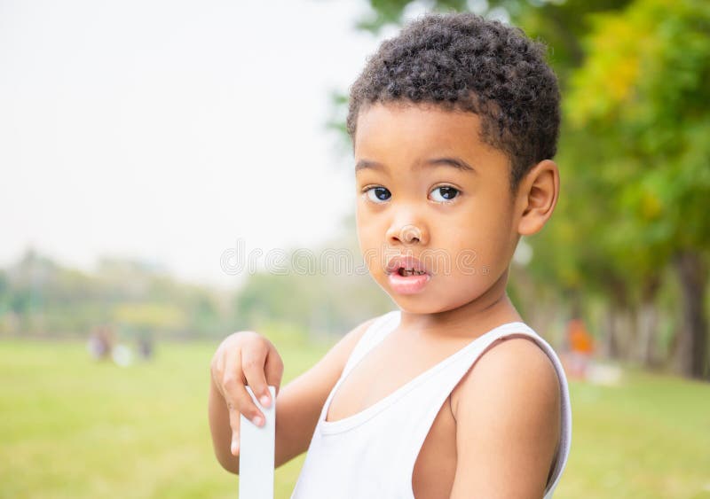 Portrait of Little Boy Playing Outdoors in a Park and Looking at Camera ...