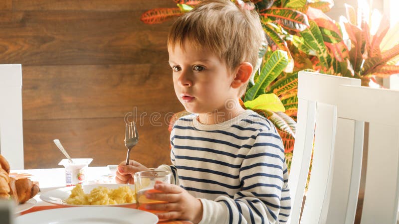 Portrait of Little 3 Years Old Boy Sitting Behind Dining Table while ...