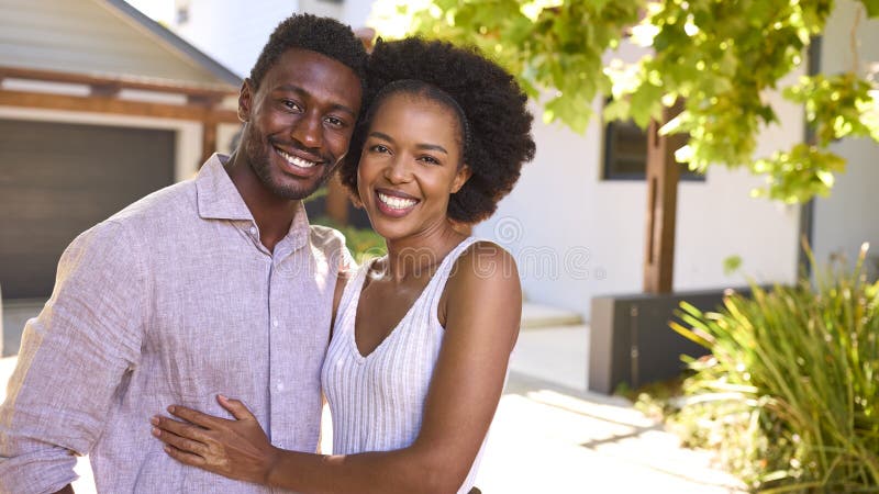 Portrait of Loving Couple Outdoors Hugging in Front of Home Stock Photo ...