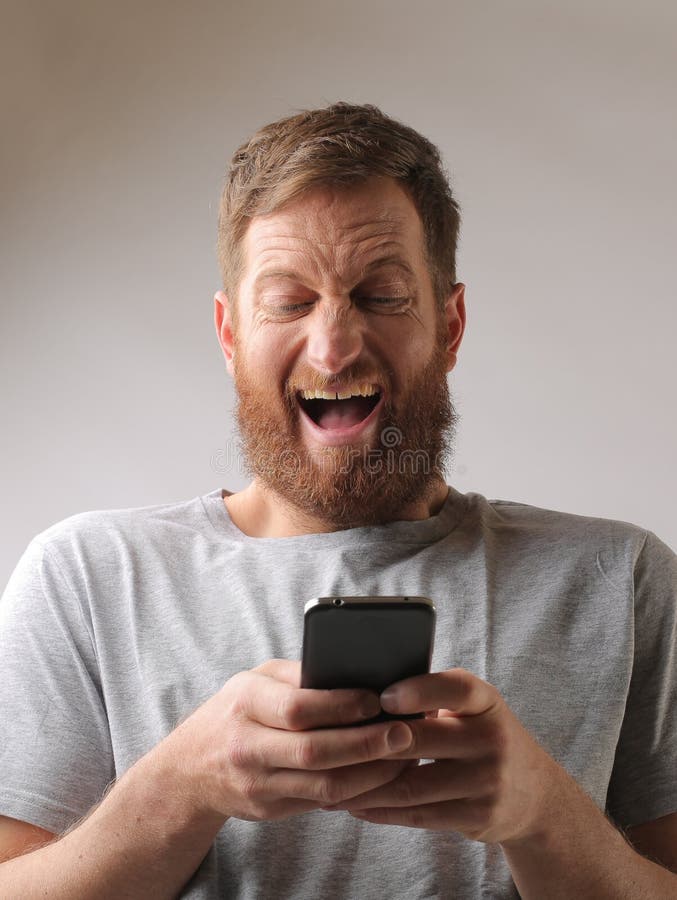Portrait of a Male with a Beard Getting Excited about a Text Message ...