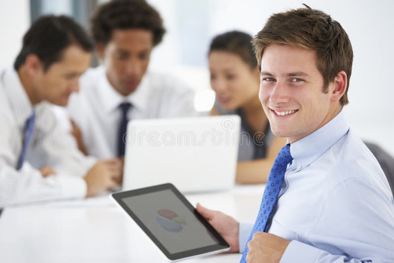 Portrait of Male Executive Using Tablet Computer with Office Meeting in ...