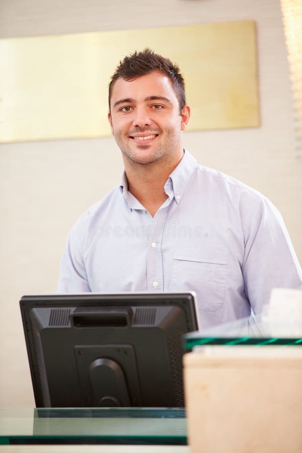 Friendly Hotel Worker at Reception Desk Stock Photo - Image of desk ...