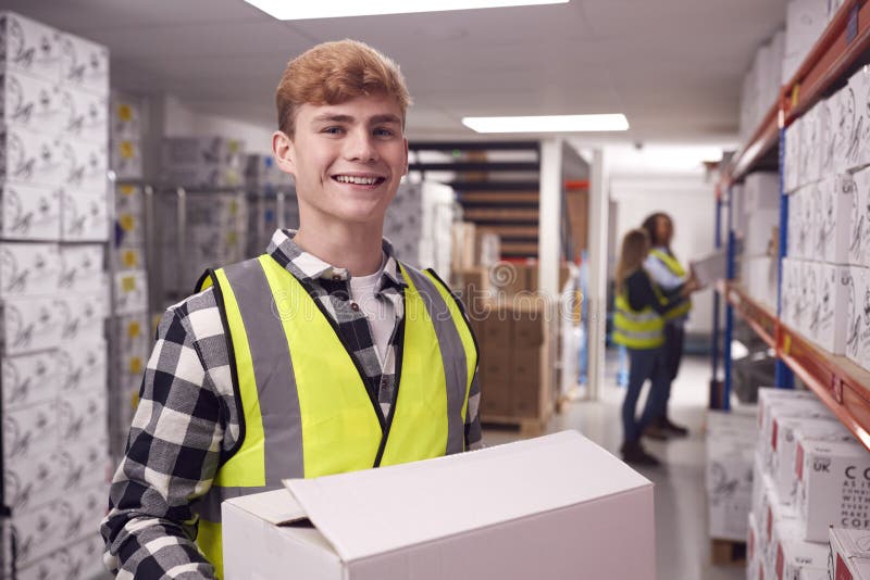 Portrait of Male Worker Inside Busy Warehouse Carrying Box Stock Photo ...