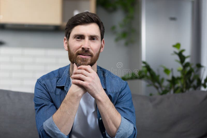 Portrait of a Man with a Beard at Home, Sitting on the Couch and ...