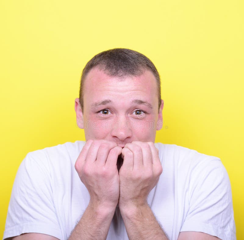 Portrait of a Man Biting Nails and Being Scared Against Gray Background ...