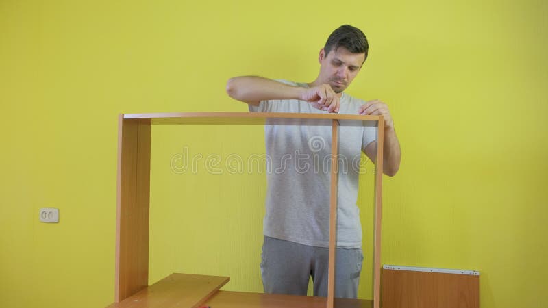 Man Is Collecting Parts Of Computer Table Screwing Shelf Using Screwdriver Stock Footage