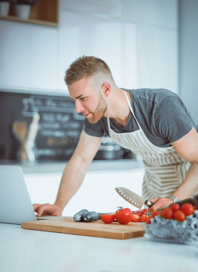 Portrait of Man Cooking Vegetable in the Kitchen while Looking at a ...