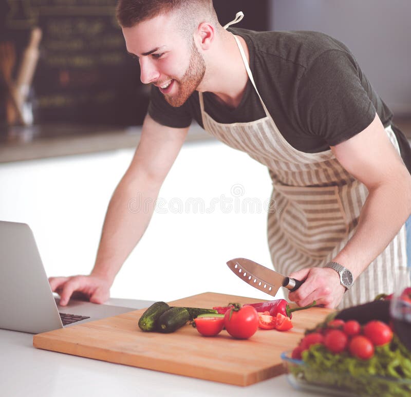 Portrait of Man Cooking Vegetable in the Kitchen while Looking at a ...
