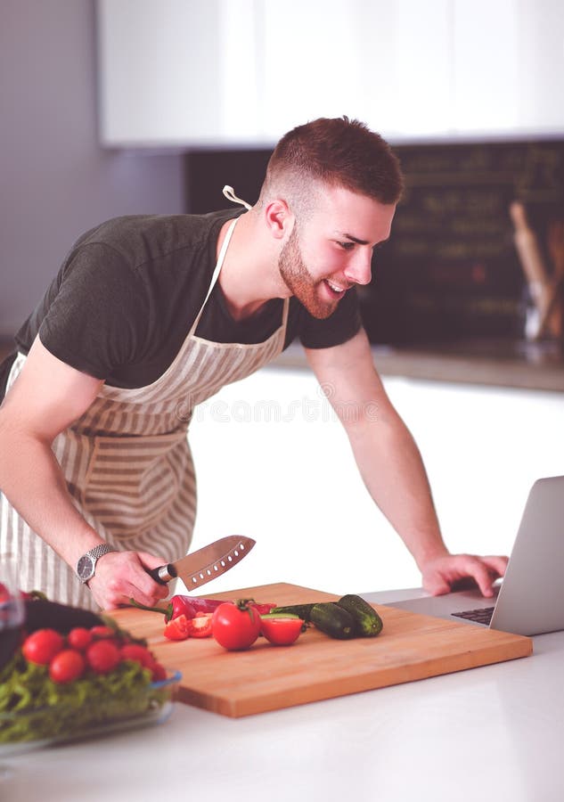 Portrait of Man Cooking Vegetable in the Kitchen while Looking at a ...