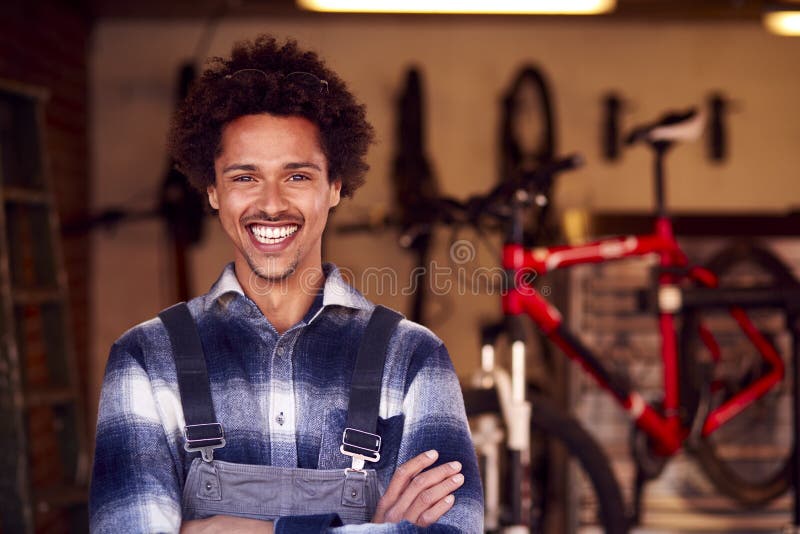 Portrait of Man in Garage at Home with Cycle Hanging on Wall Behind ...