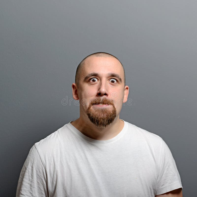 Portrait Of A Man Making Funny Face Against Gray Background Stock Photo ...