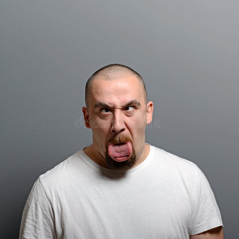Portrait Of A Man Making Funny Face Against Gray Background Stock Photo ...