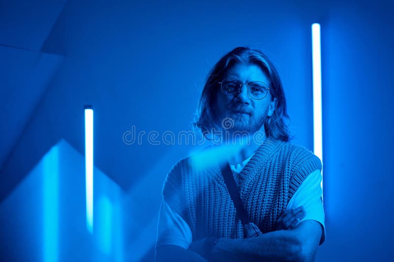 Portrait of Man in Neon Blue Light Setting with Folded Arms Stock Image ...