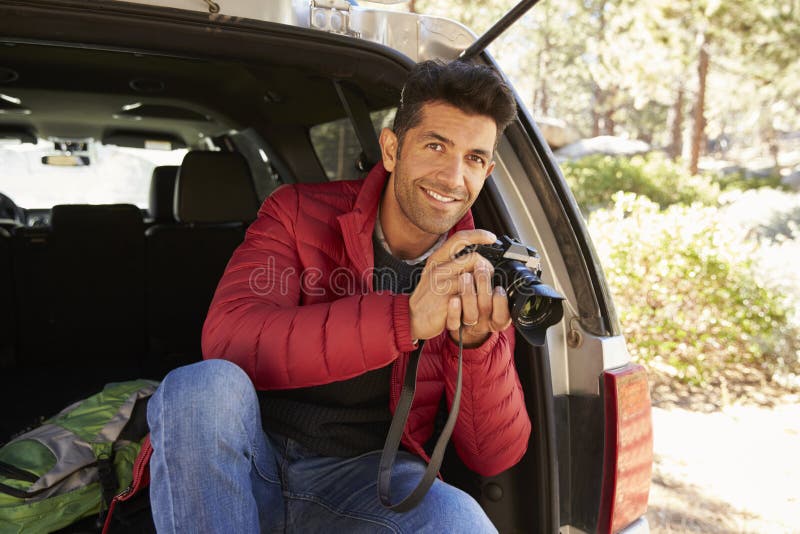 Portrait of Man in the Open Back of Car Holding Camera Stock Image ...