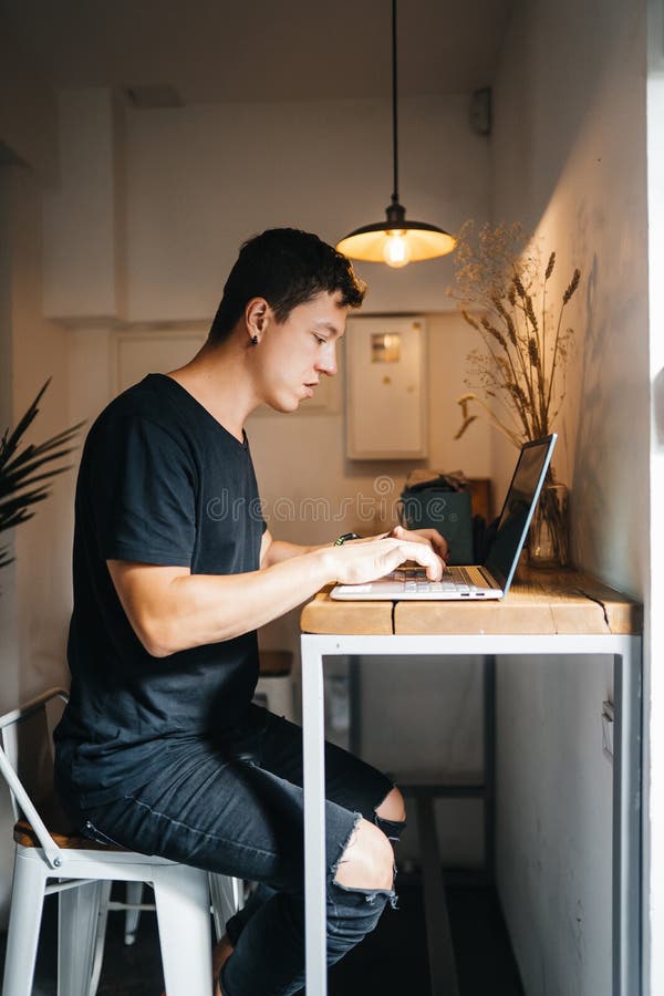 Portrait of Man Sitting at a Table at Home Working on a Laptop. Stock ...