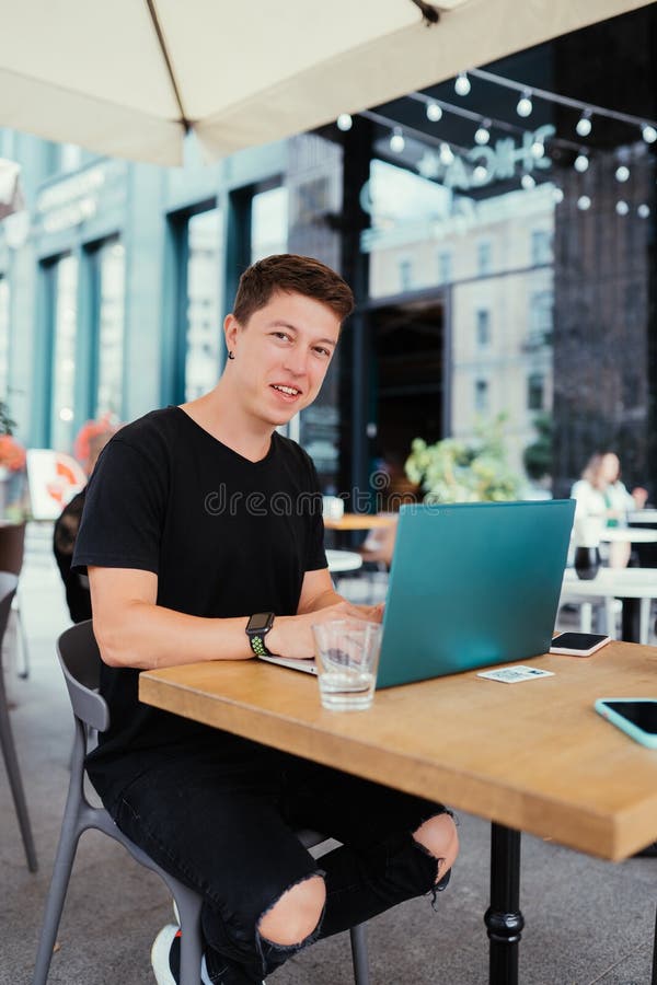 Portrait of Man Sitting at a Table Working on a Laptop Computer. Stock ...