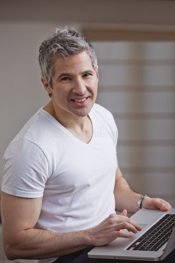 Portrait of a Man Using a Laptop and Smiling Stock Image - Image of ...