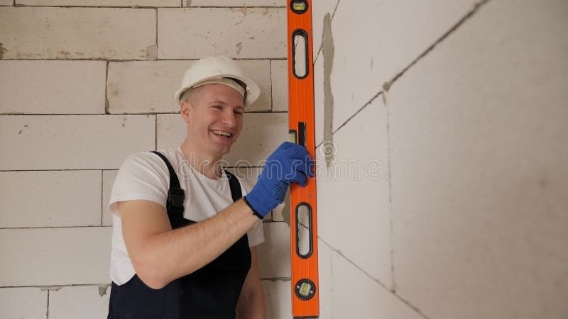 Portrait of a Man Working at Home and Measuring the Wall Level with ...