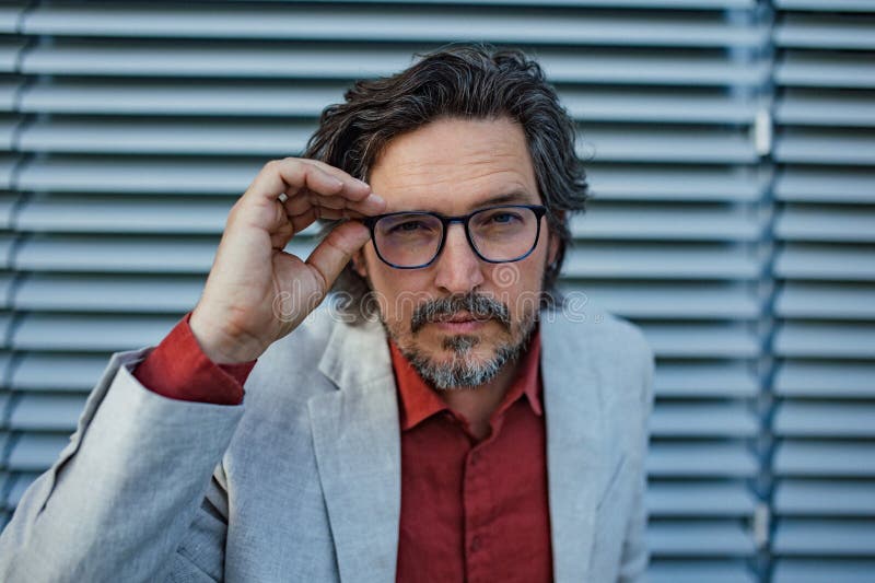 Portrait Of Mature Businessman Standing On City Street In Front Of