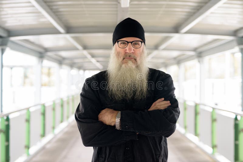 Mature Bearded Man With Arms Crossed At Footbridge In The City Stock