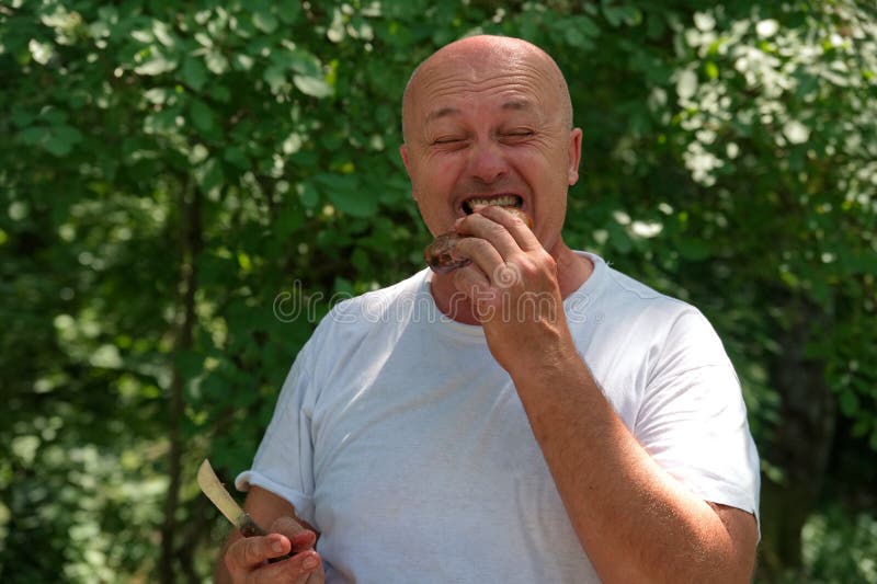 Mature Man Eating Roasted Pork Stock Photo - Image of snack, portrait ...