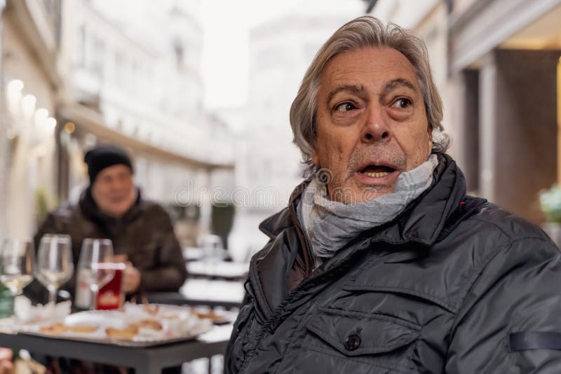 Portrait of Mature Man with Surprised Expression Sitting Outside a Bar ...