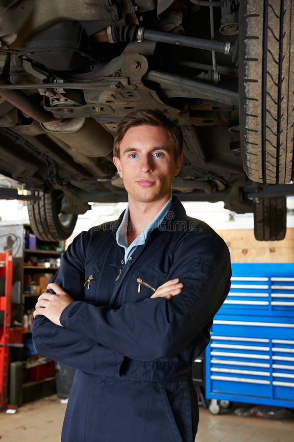 Portrait Of Mechanic Working On Wheel Underneath Car Stock Photo ...