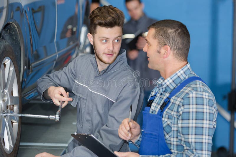 Portrait Mechanic Supervising Apprentices Work Stock Image - Image of ...
