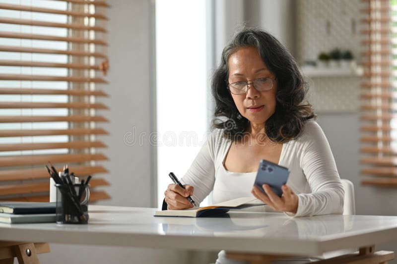 Portrait of Middle Aged Lady Reading Information on Mobile Phone and ...