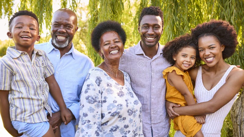 Portrait of Multi-Generation Family Standing in Garden Smiling at ...