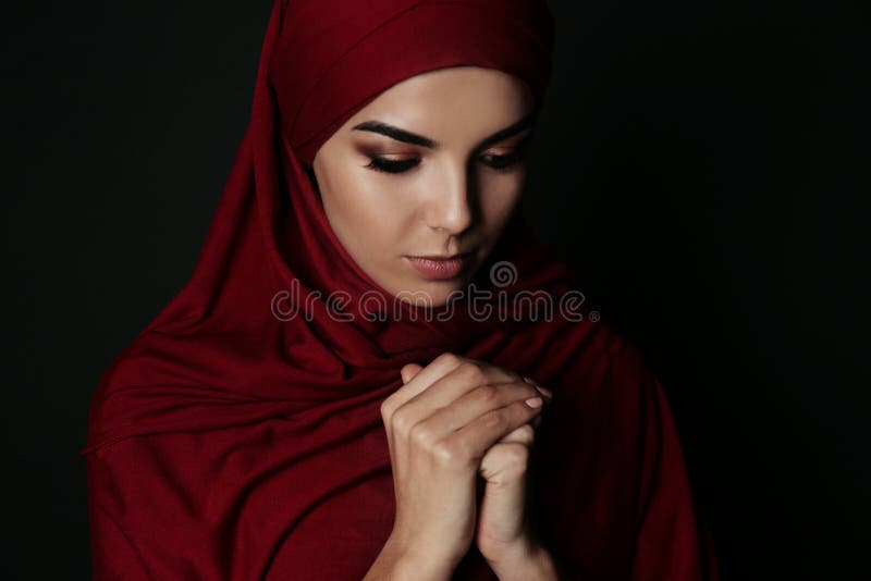 Portrait Of Sad Muslim Woman In Hijab Praying On Dark Background Stock