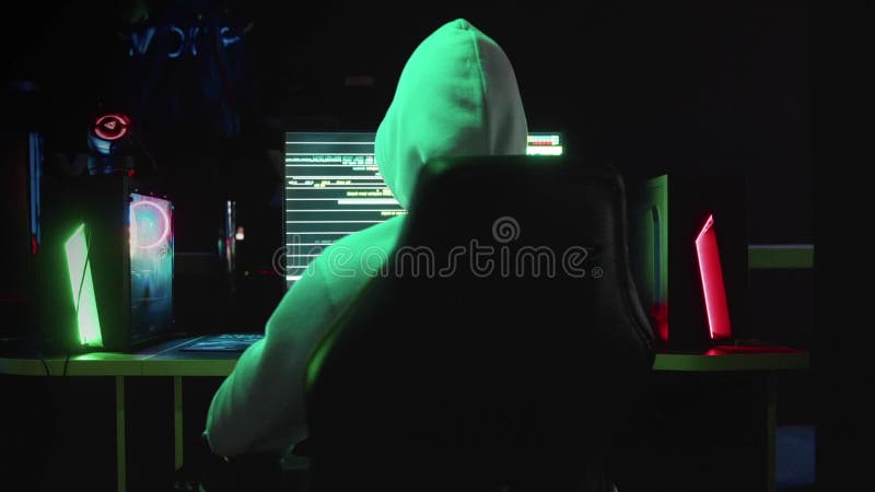 Portrait of a Mysterious Hacker in a Hood, Sitting at a Table and ...